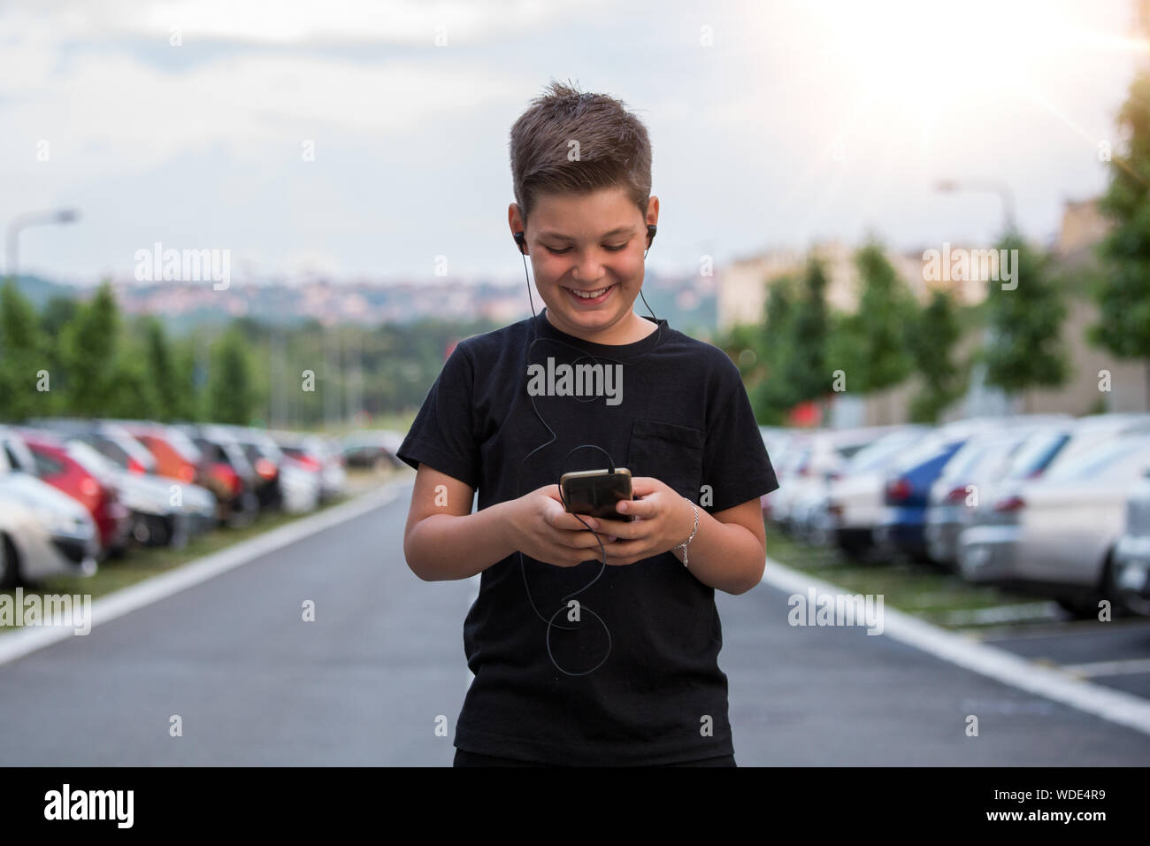 Teenage boy smiling while texting his friends via social networks using ...
