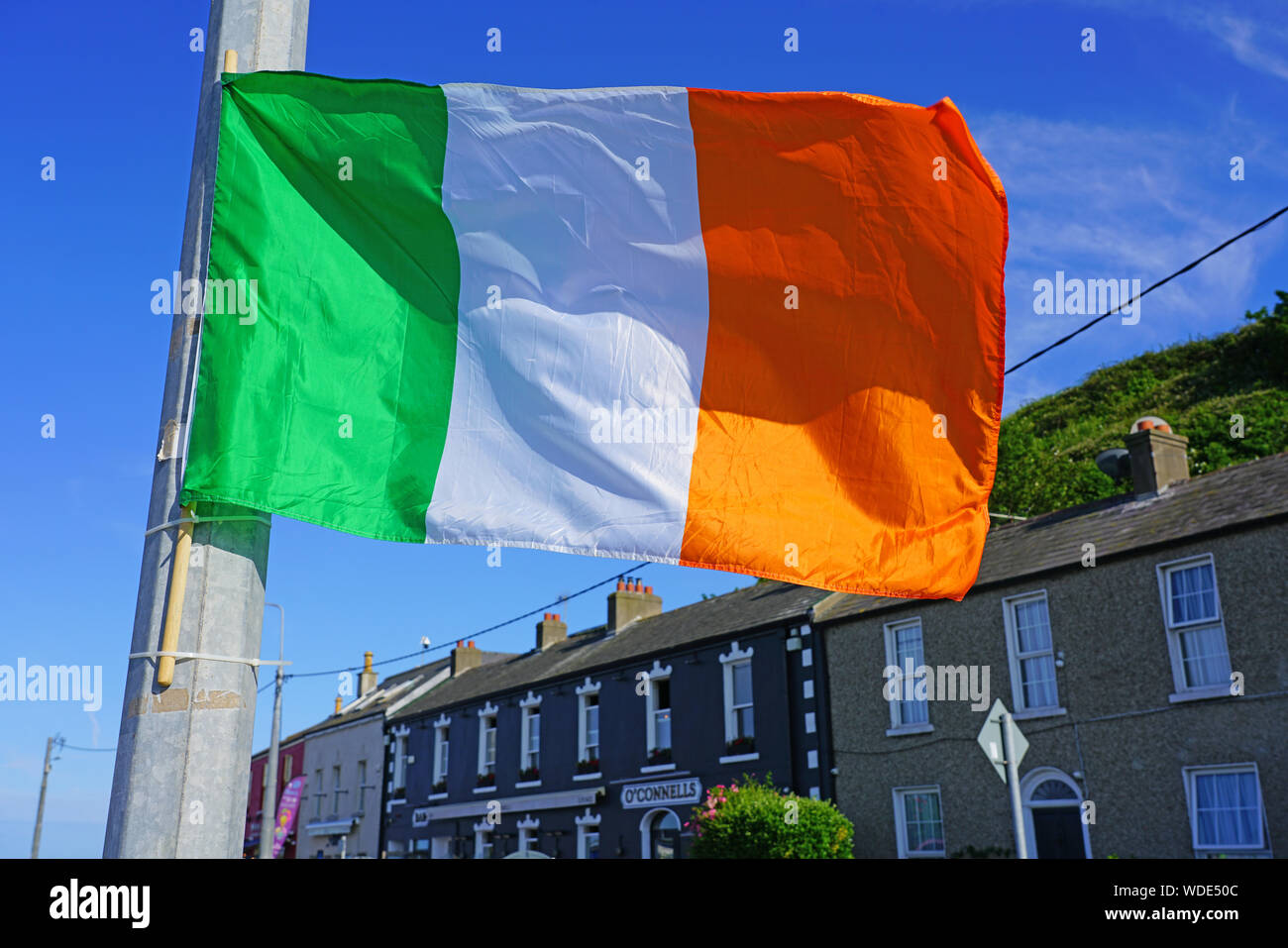 HOWTH, IRELAND- 27 JUL 2019- View of an Irish flag floating in the wind ...