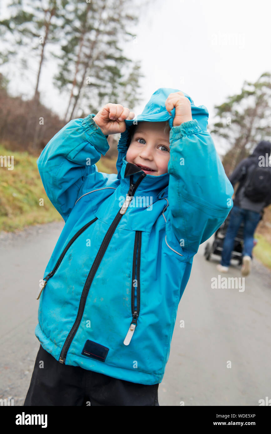 Boy Putting On Coat