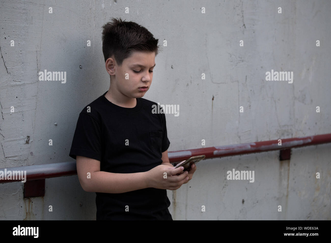 Portrait of a sad teenage boy on the phone looking thoughtful about ...
