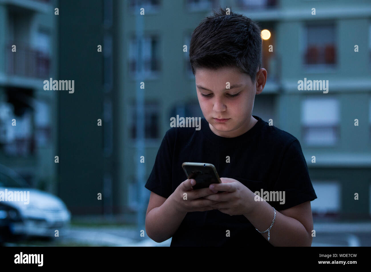 Portrait of a sad teenage boy on the phone looking thoughtful about ...