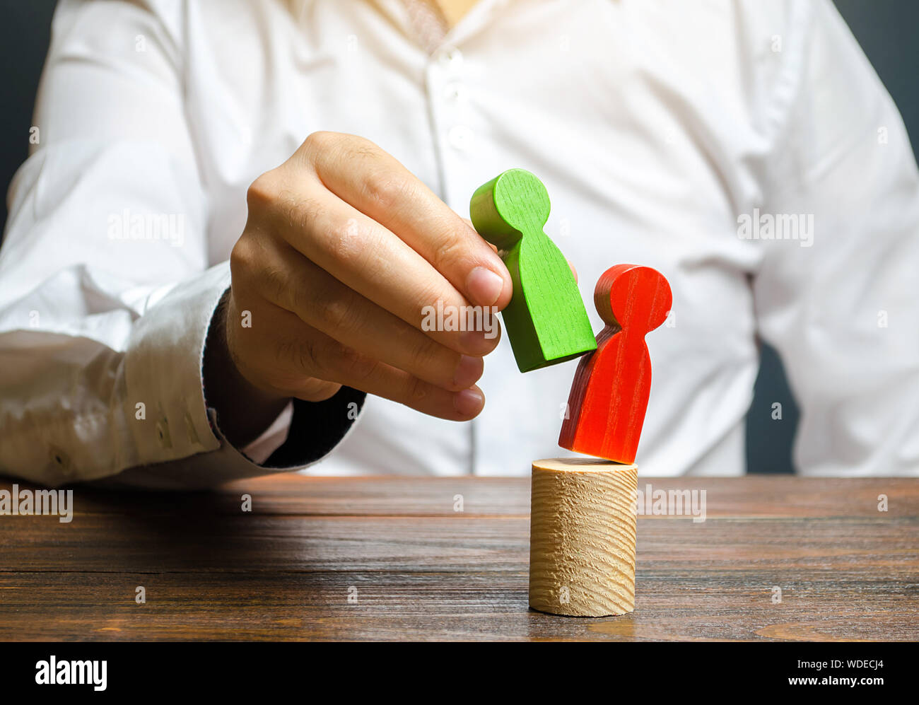 A person replaces a red human figure with a green one. firing staff ...