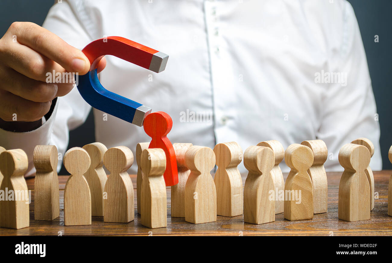 The leader with a magnet pulls a red human figure out of crowd ...