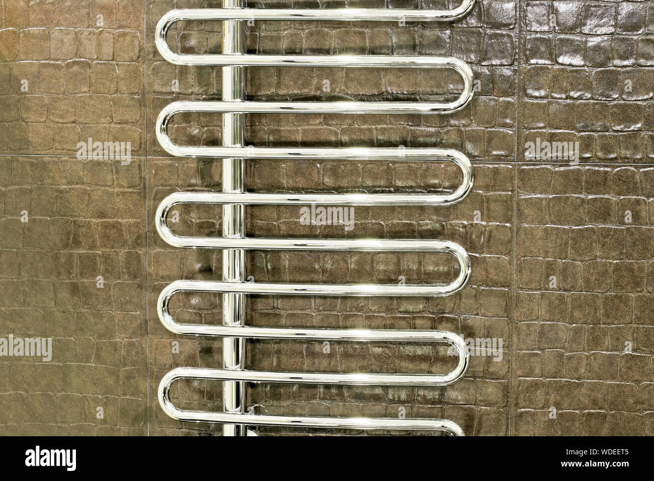Unusual silver metal heater over textured wall Stock Photo - Alamy