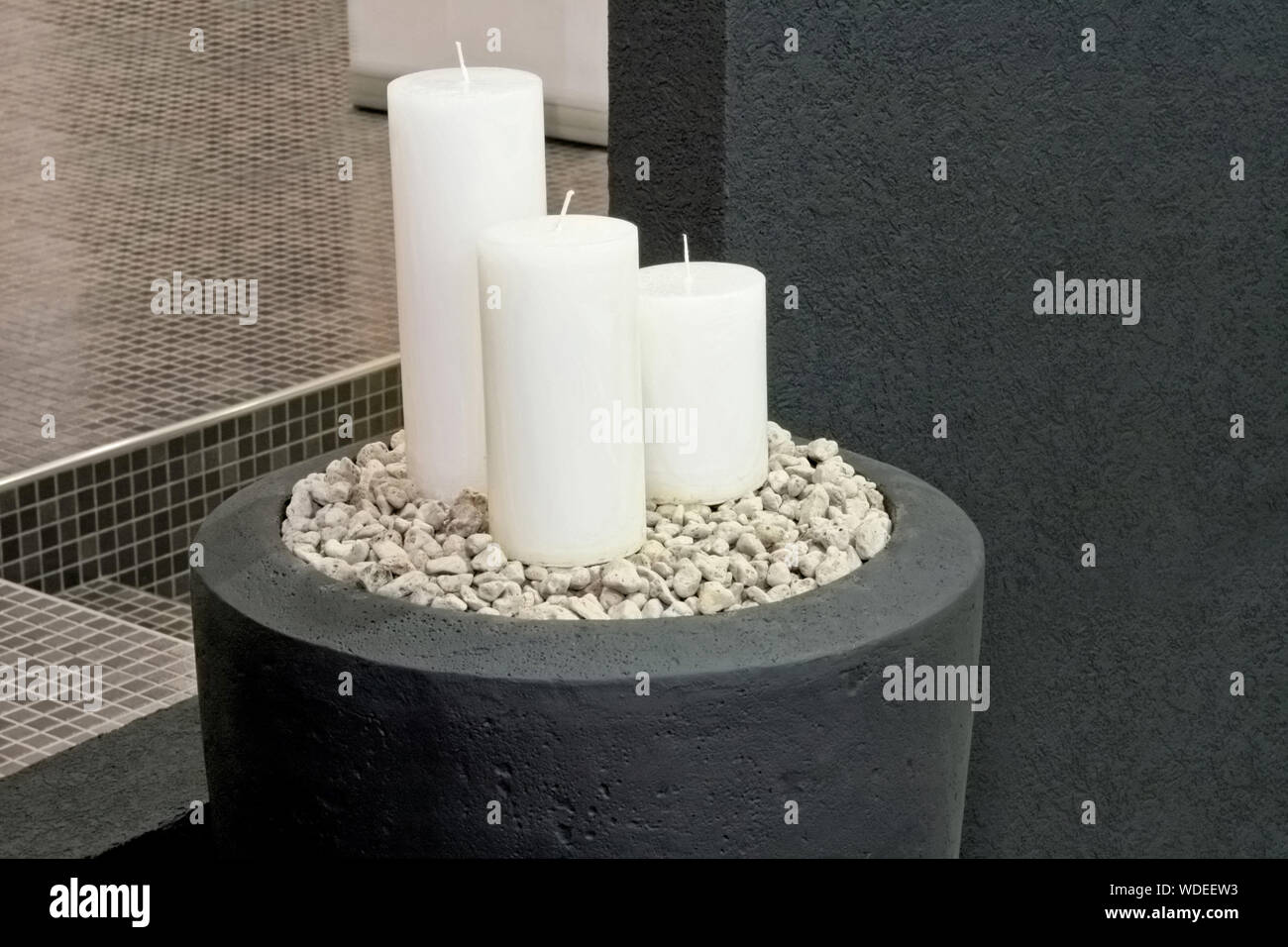 Three white wax candles on the stone Stock Photo - Alamy