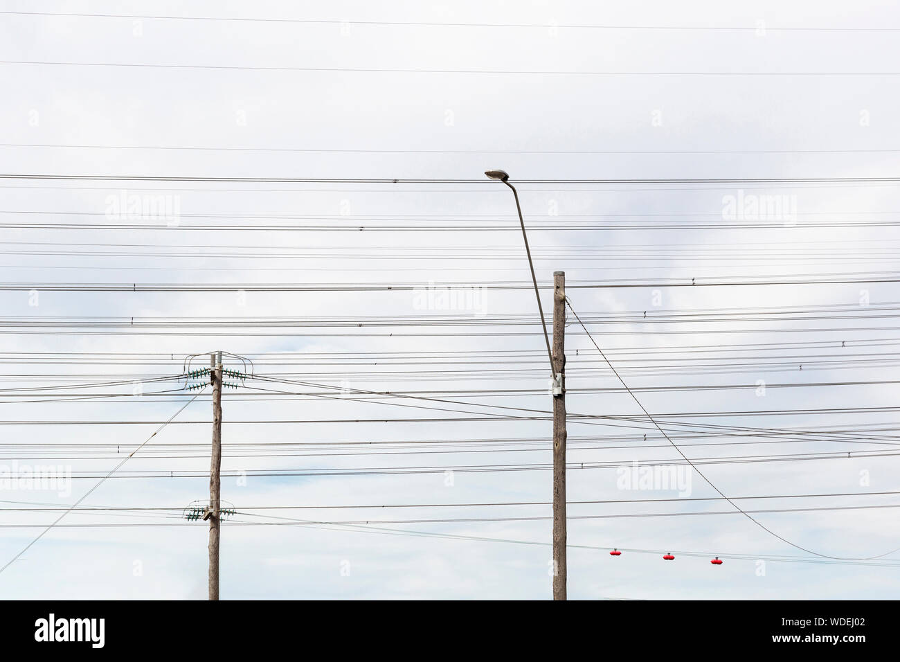 Streetlight standing against powerlines strung together Stock Photo - Alamy