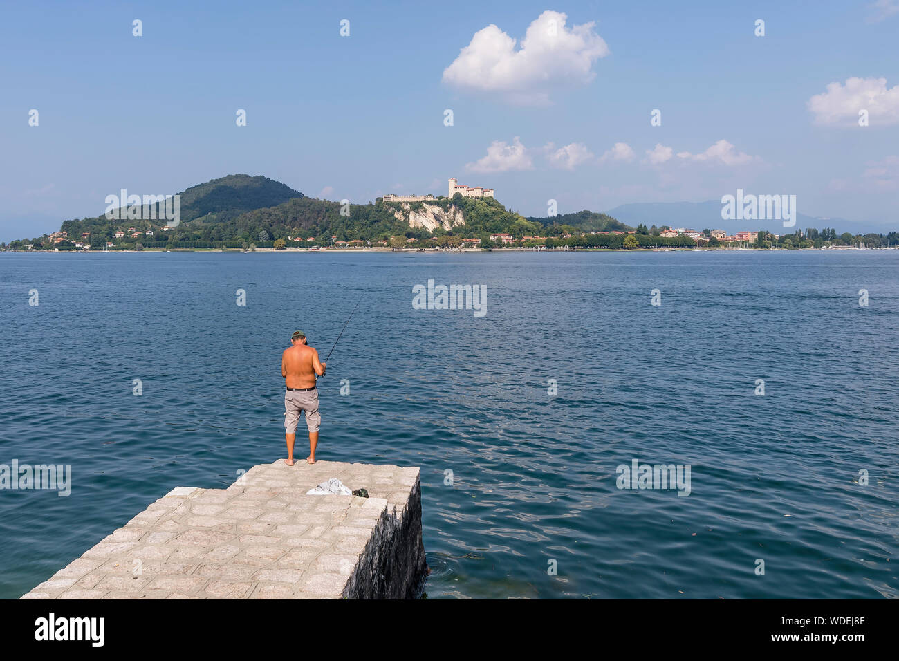 Lone fisherman on the shore of Lake Maggiore in Arona, Novara, Italy ...
