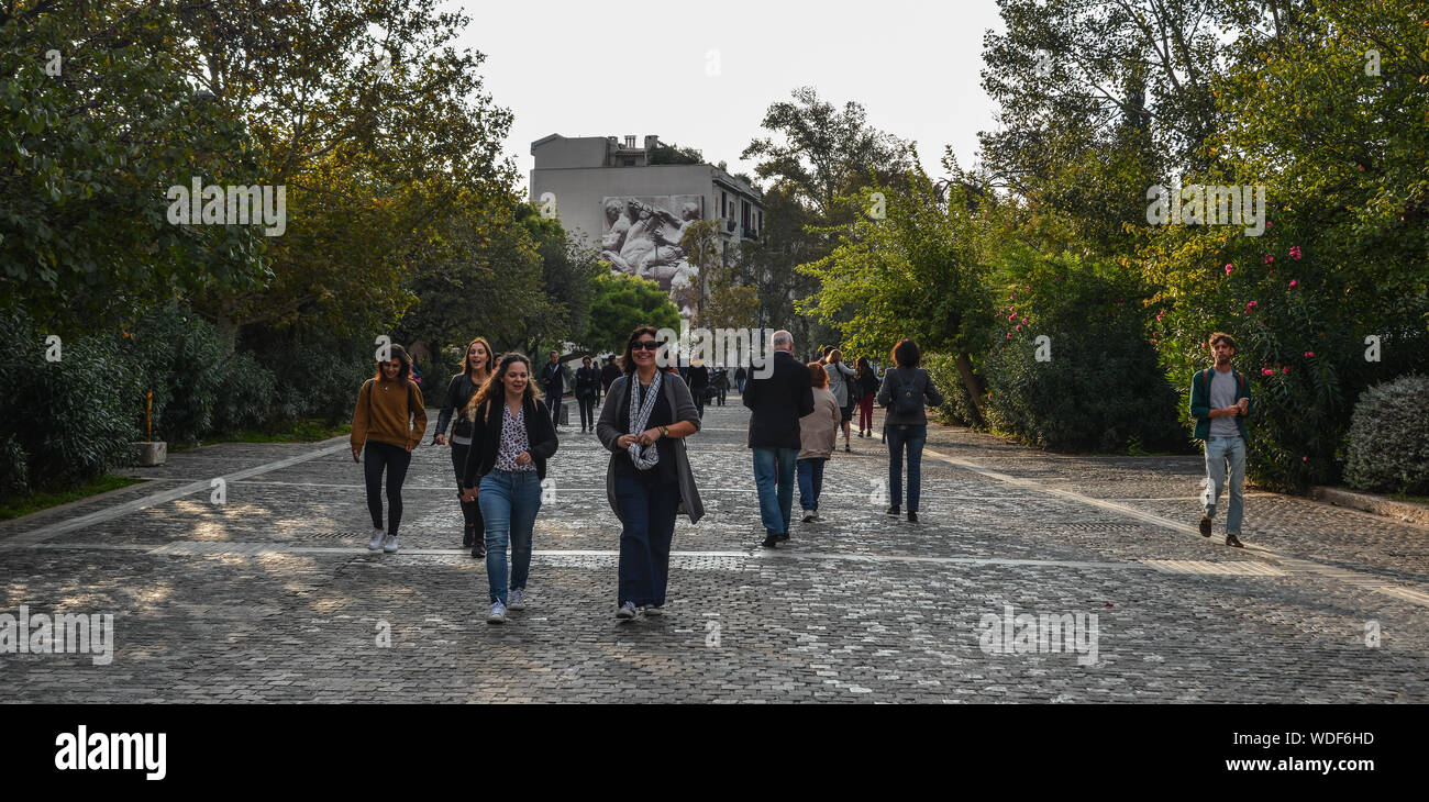 Athens, Greece - Oct 10, 2018. People walking on the cobblestone road ...
