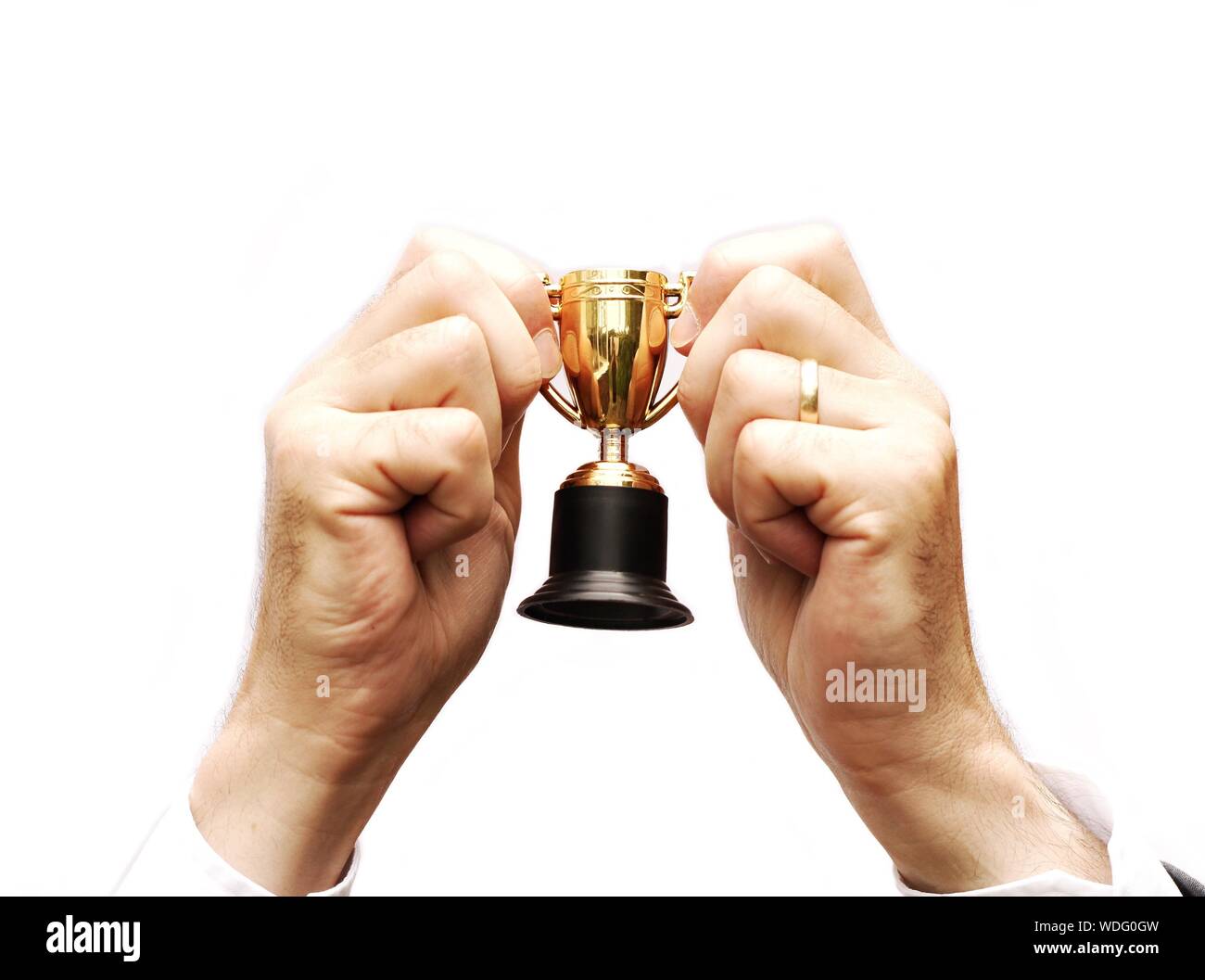 Hand holding up gold trophy hi-res stock photography and images - Alamy