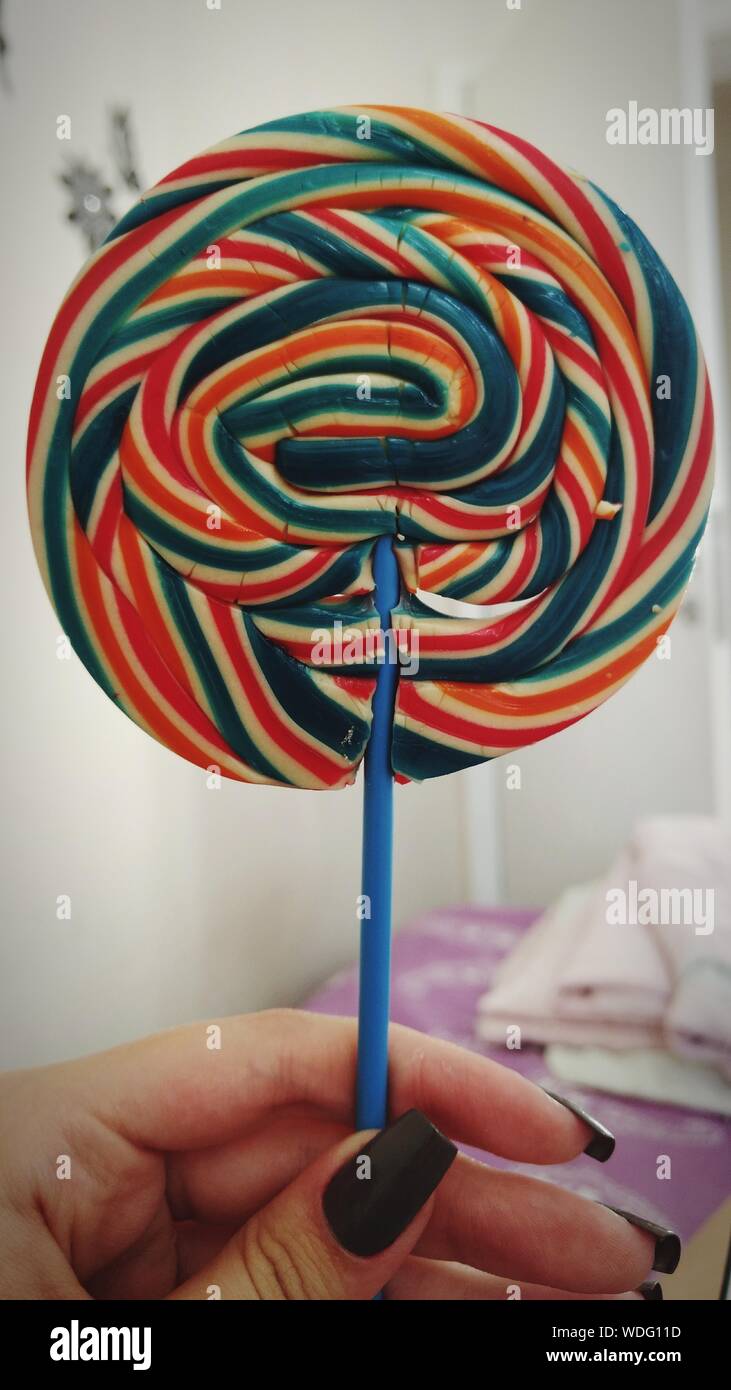 Hand holding lollipop hi-res stock photography and images - Alamy