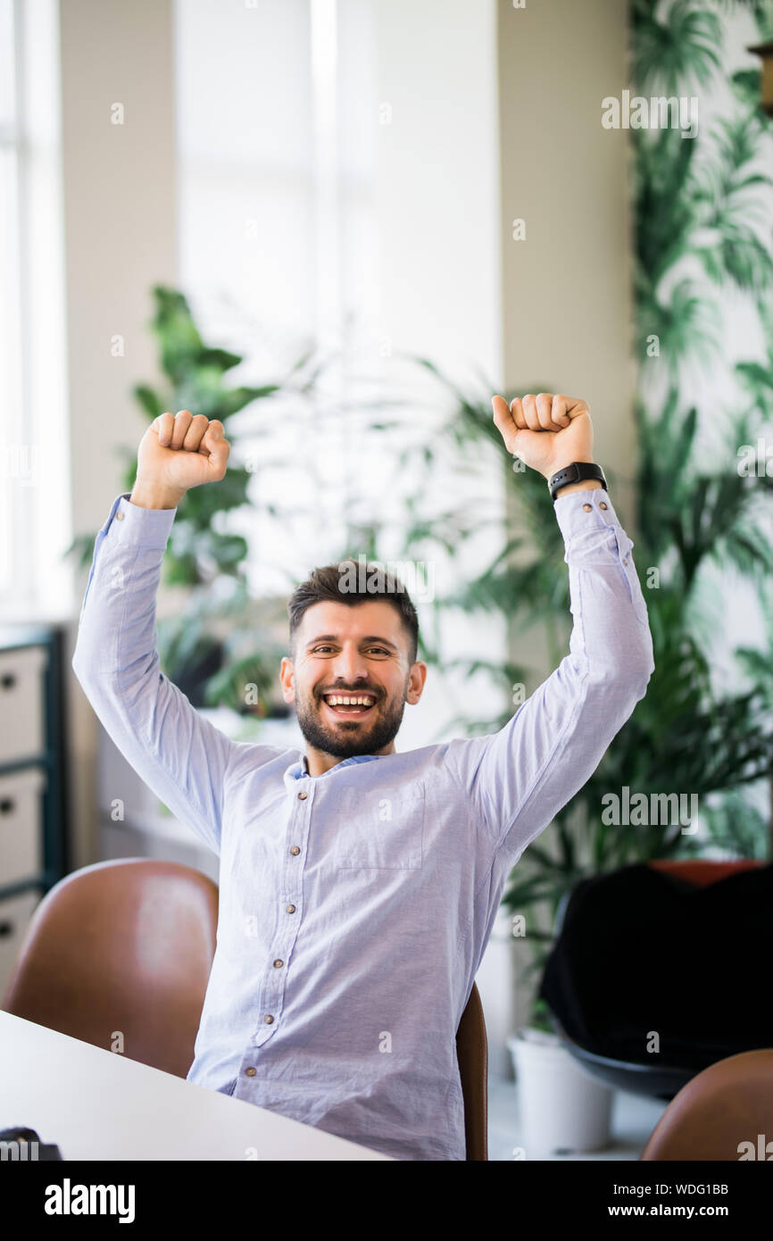 Happy man completed task and triumphing with raised hands Stock Photo ...