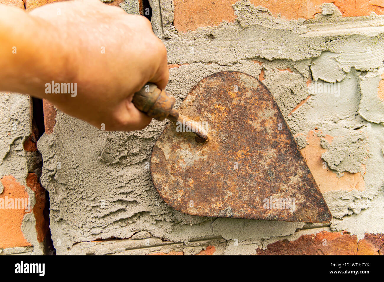 Spatula in the hand of the builder - repair of a brick wall. Place for ...