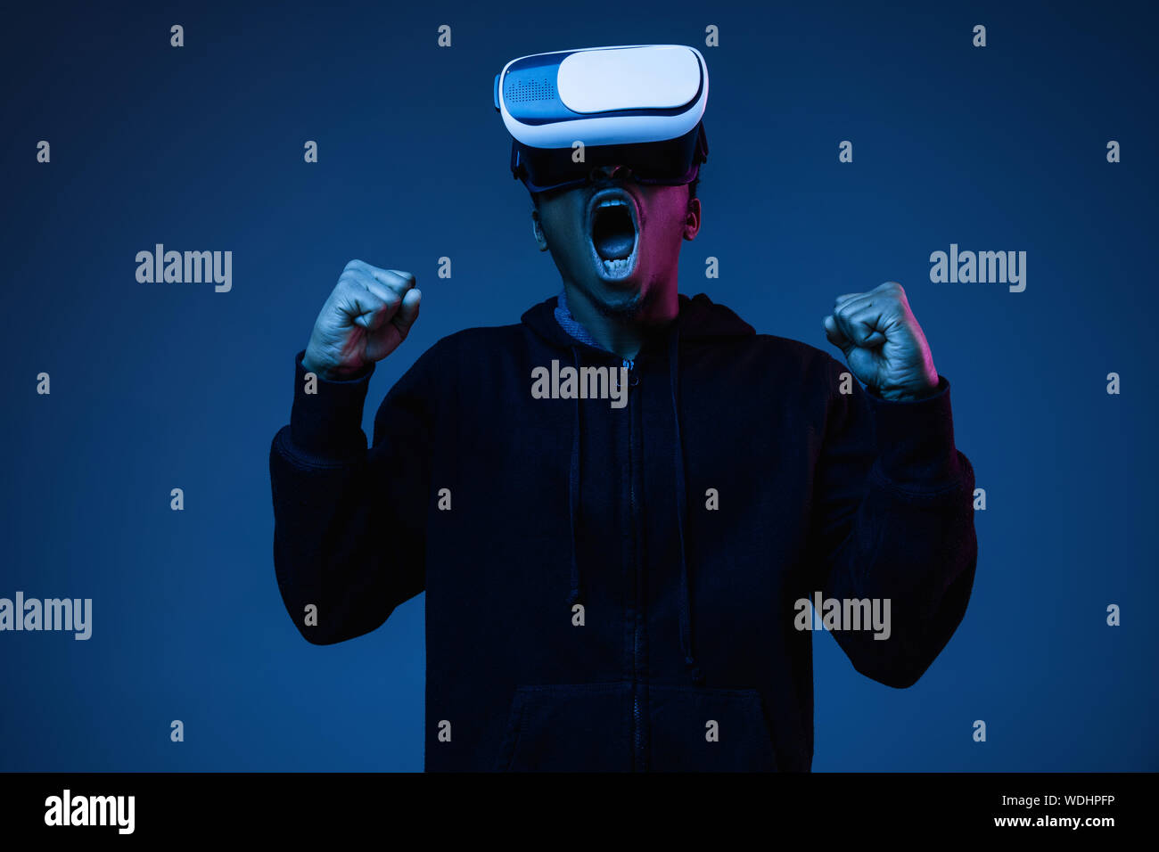 Young african-american man's screaming in VR-glasses in neon on ...