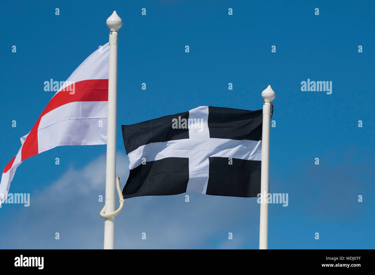 The St George’s Flag and St Piran flag flying from flagpoles against a ...