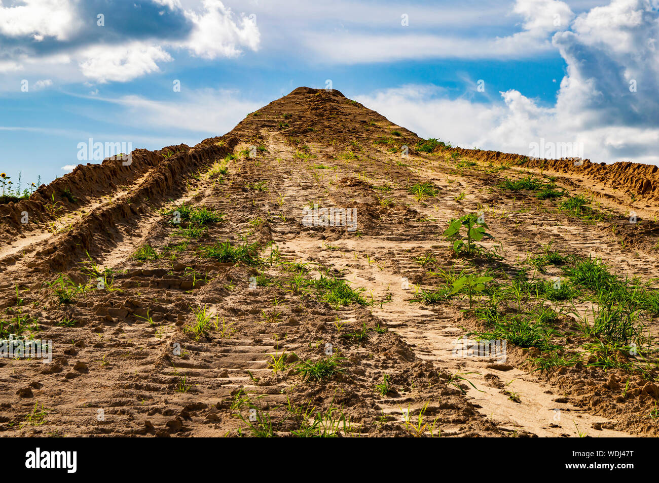 Sandy mountain against the blue sky with clouds. Background Stock Photo ...