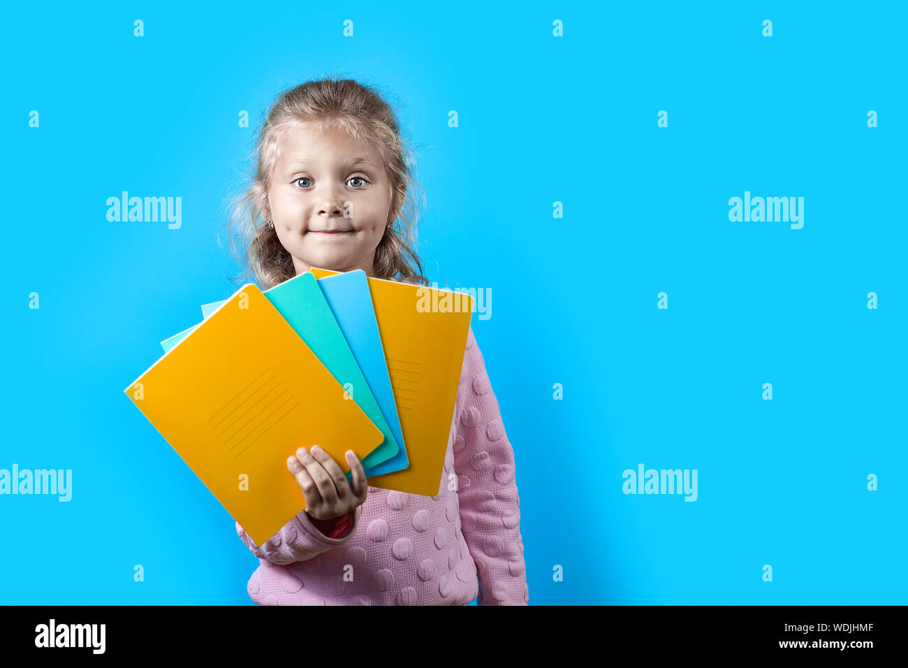 Cute cheerful girl with dimples on her cheeks and curly hair holding ...