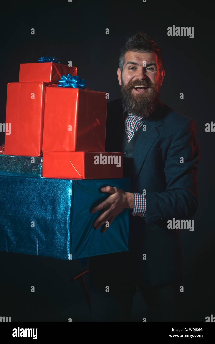 Man or businessman holds pile of gifts on black background. Hipster ...