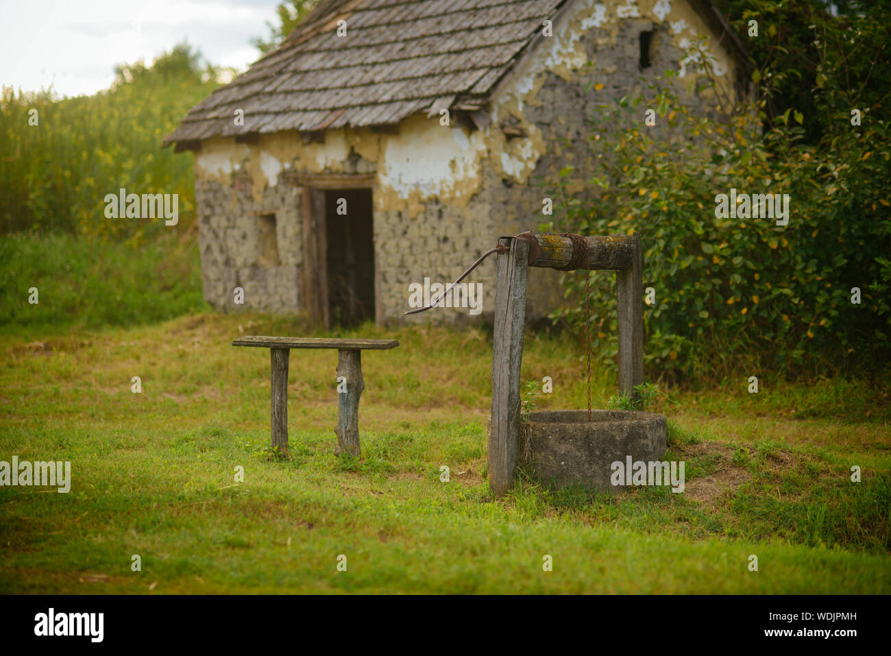 Village with abandoned building. House barrack with old well in yard ...