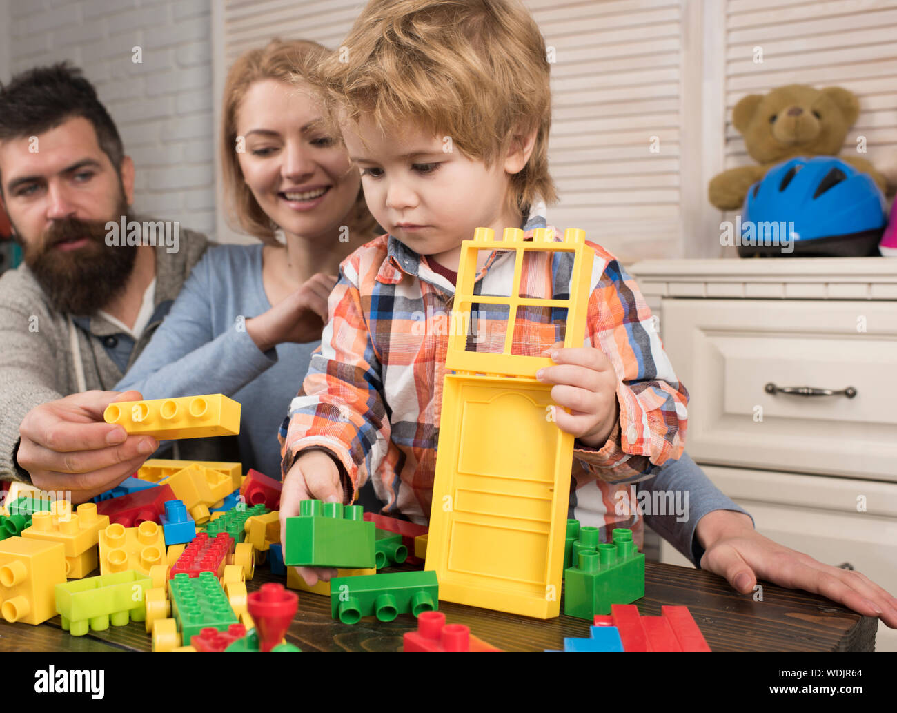Young family playing with construction plastic blocks. Family games ...