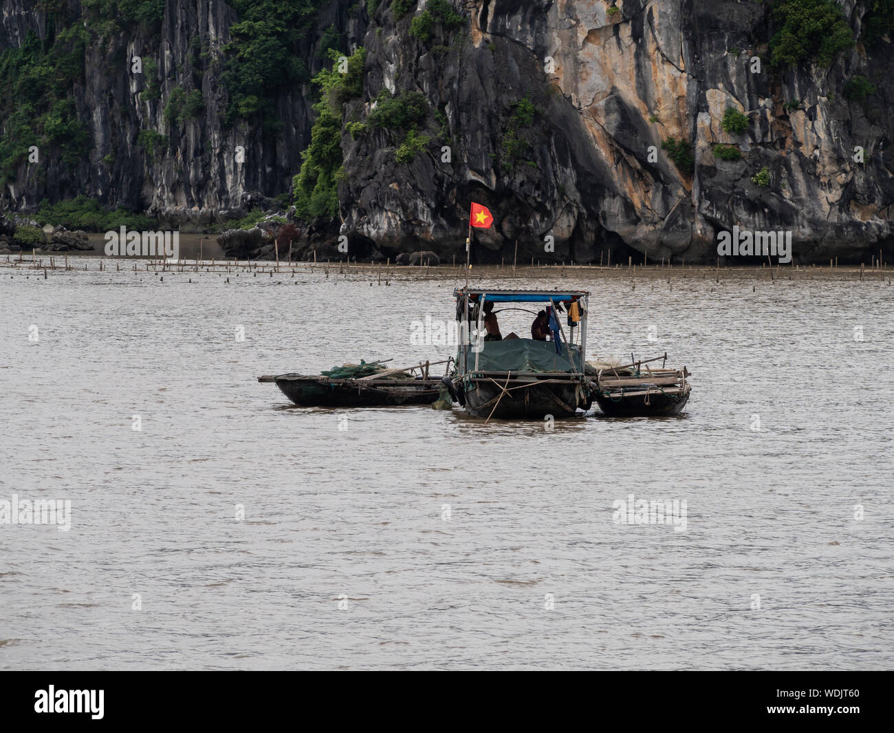Fishing boats on the water in Ha Long Bay, Vietnam, with limestone ...