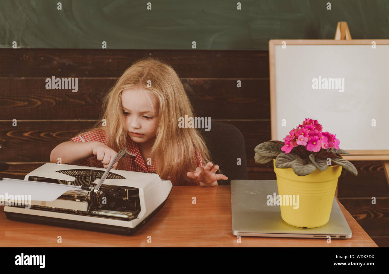 Little girl type on retro typewriter in school. Retro and archaism ...