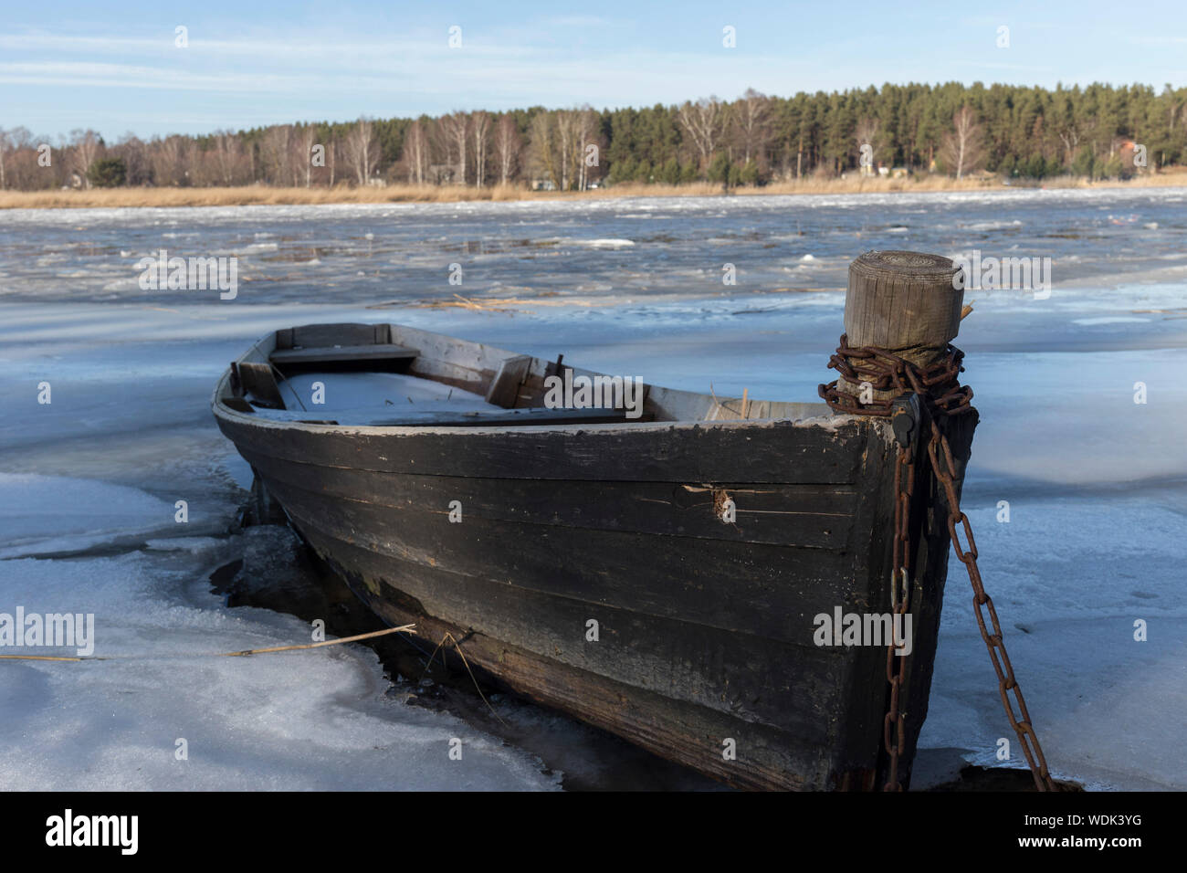 Winter scene of old wooden boat on ice of frozen lake Stock Photo - Alamy