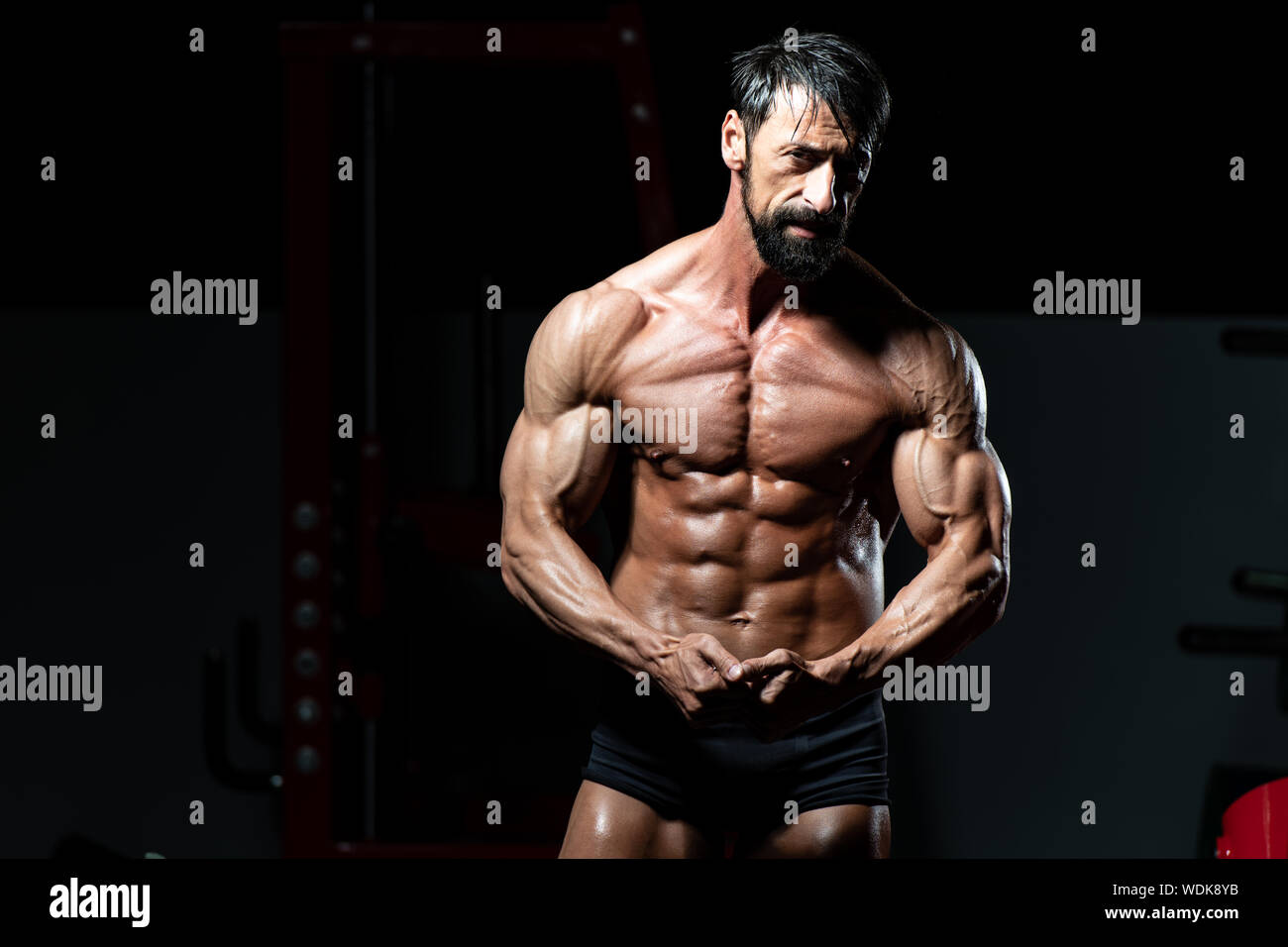 Handsome Mature Man Standing Strong In The Gym And Flexing Muscles ...