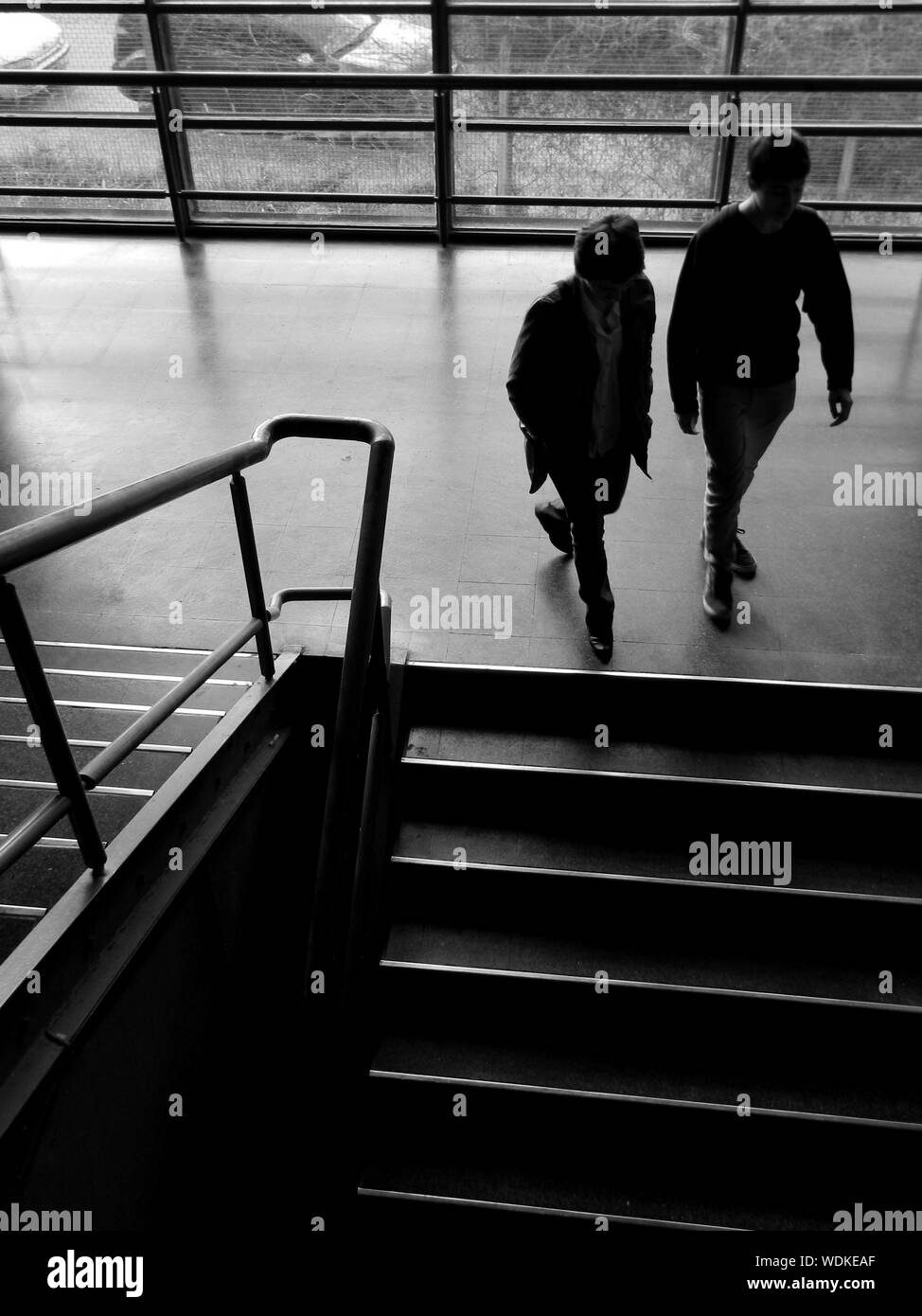 Two people walking down stairs hi-res stock photography and images - Alamy