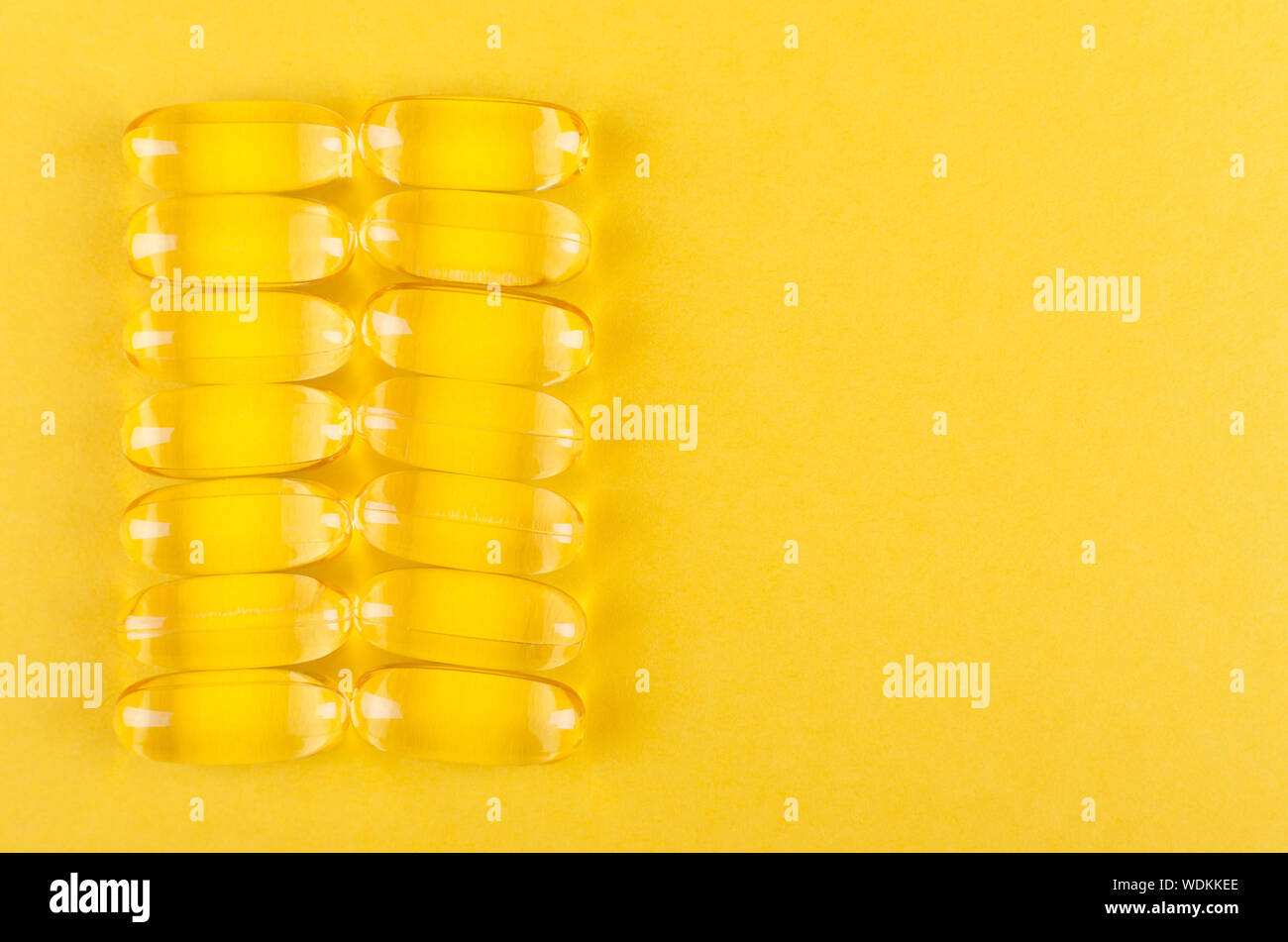 yellow capsules on yellow background with copy space Stock Photo - Alamy