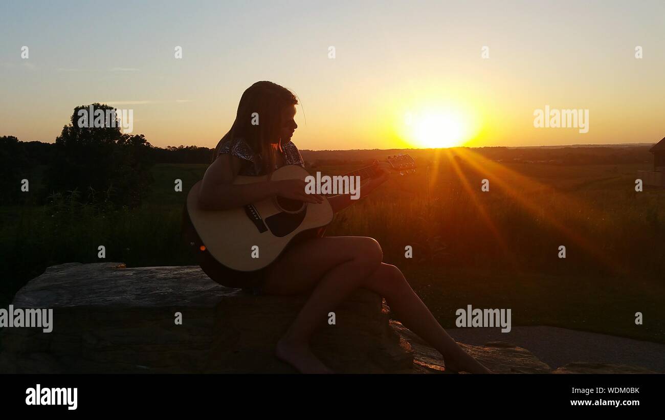 Playing guitar during the sunset hi-res stock photography and images ...