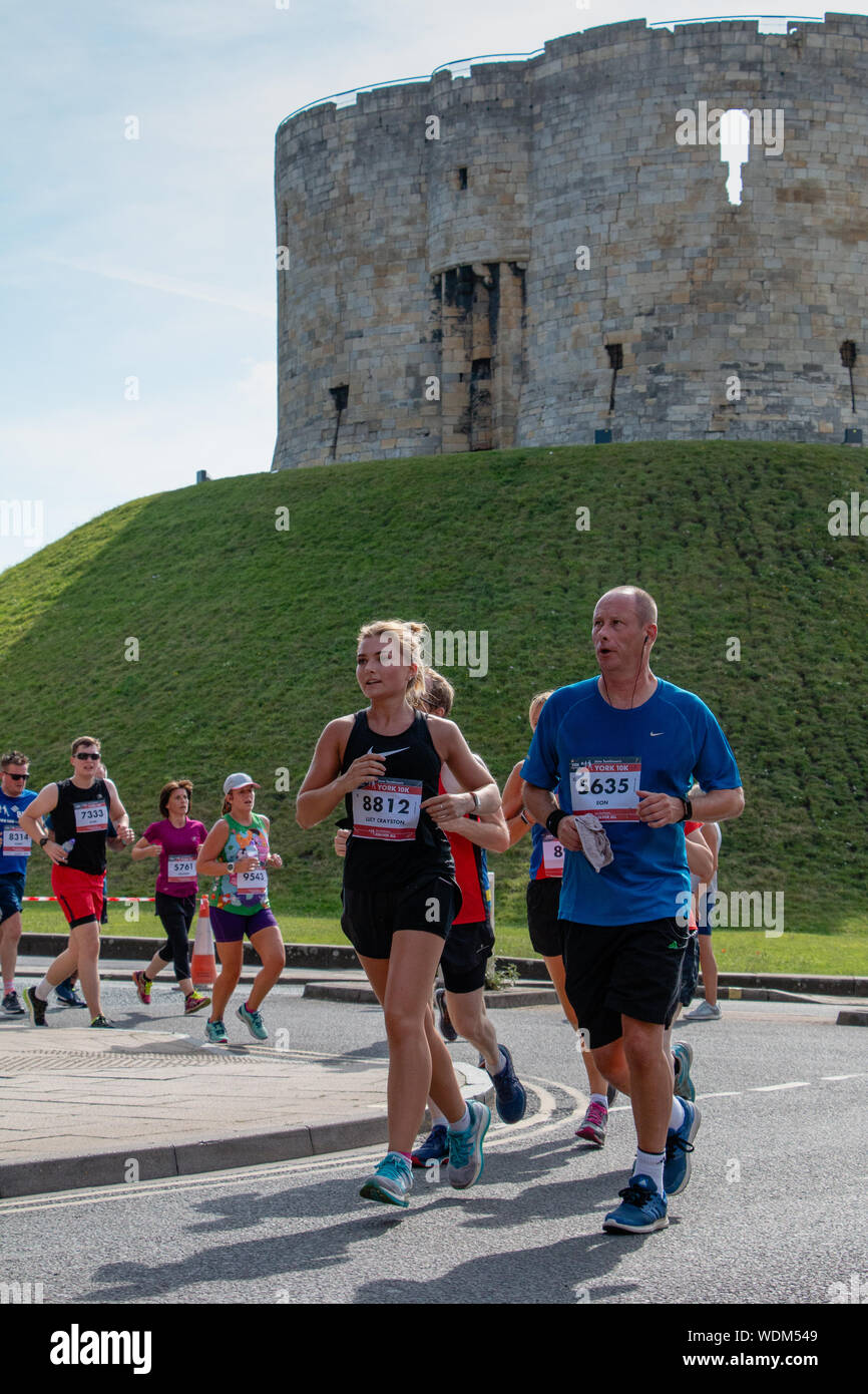 Runners turning the corner next to Clifford's Tower during the York 10k ...