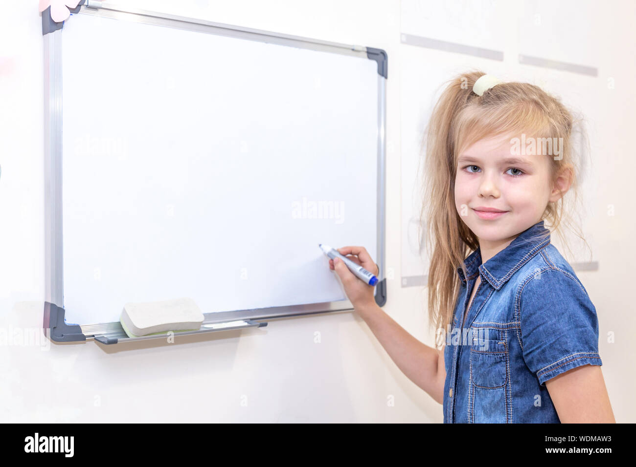 Little girl writing on board with a marker. Learning and school concept ...