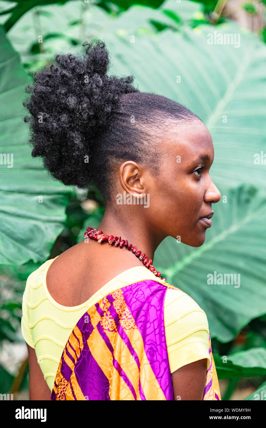Young african woman looks at camera half-turned Stock Photo - Alamy