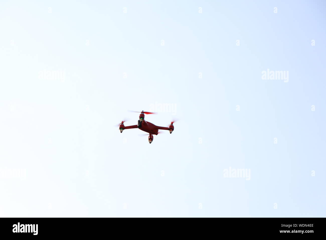 red drone on a blue sky background Stock Photo - Alamy
