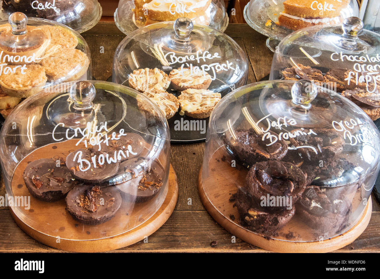 Tasty desserts on display in glass containers at a small bakery Stock ...
