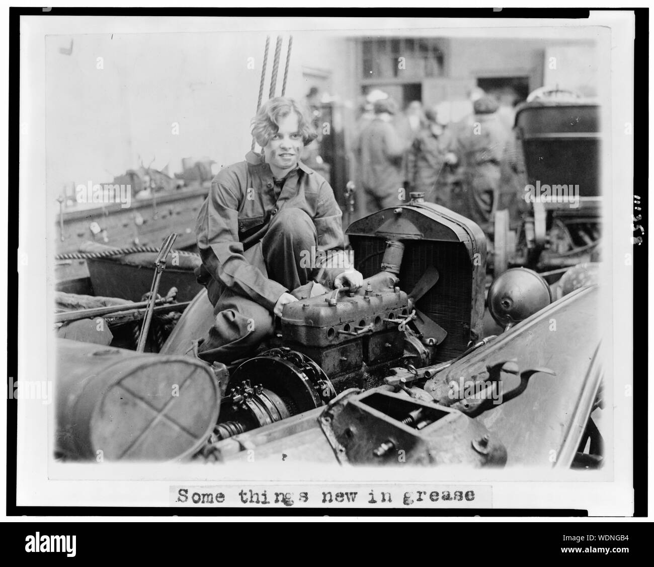Grace Wagner working on engine of automobile. Some things new in grease ...