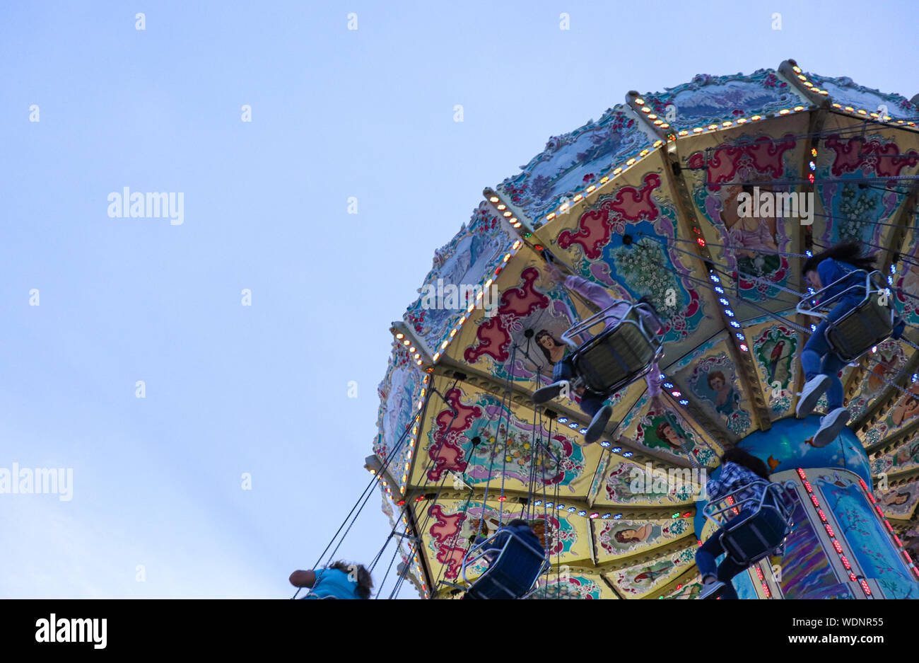 Riders on a swing carousel Stock Photo - Alamy