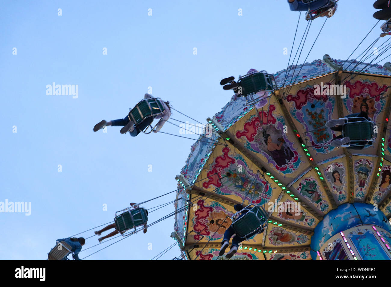 Riders on a swing carousel Stock Photo - Alamy