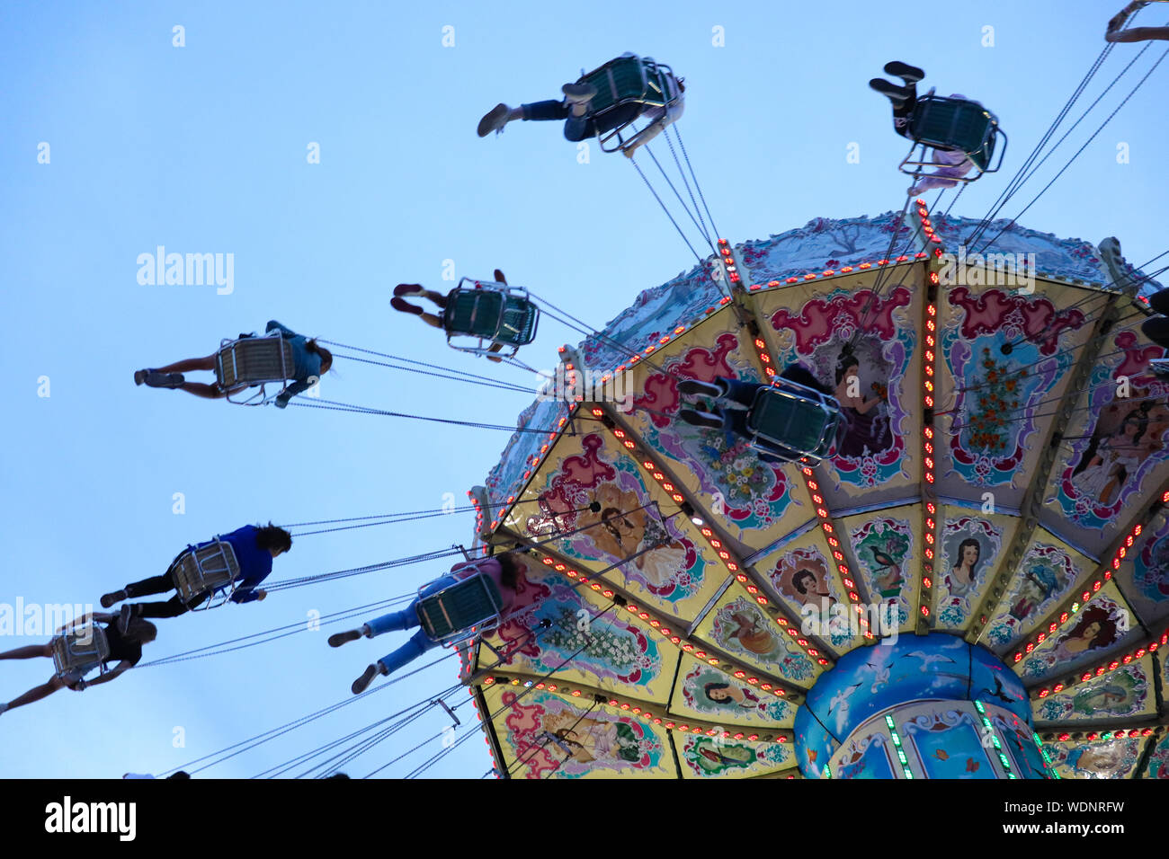 Riders on a swing carousel Stock Photo - Alamy