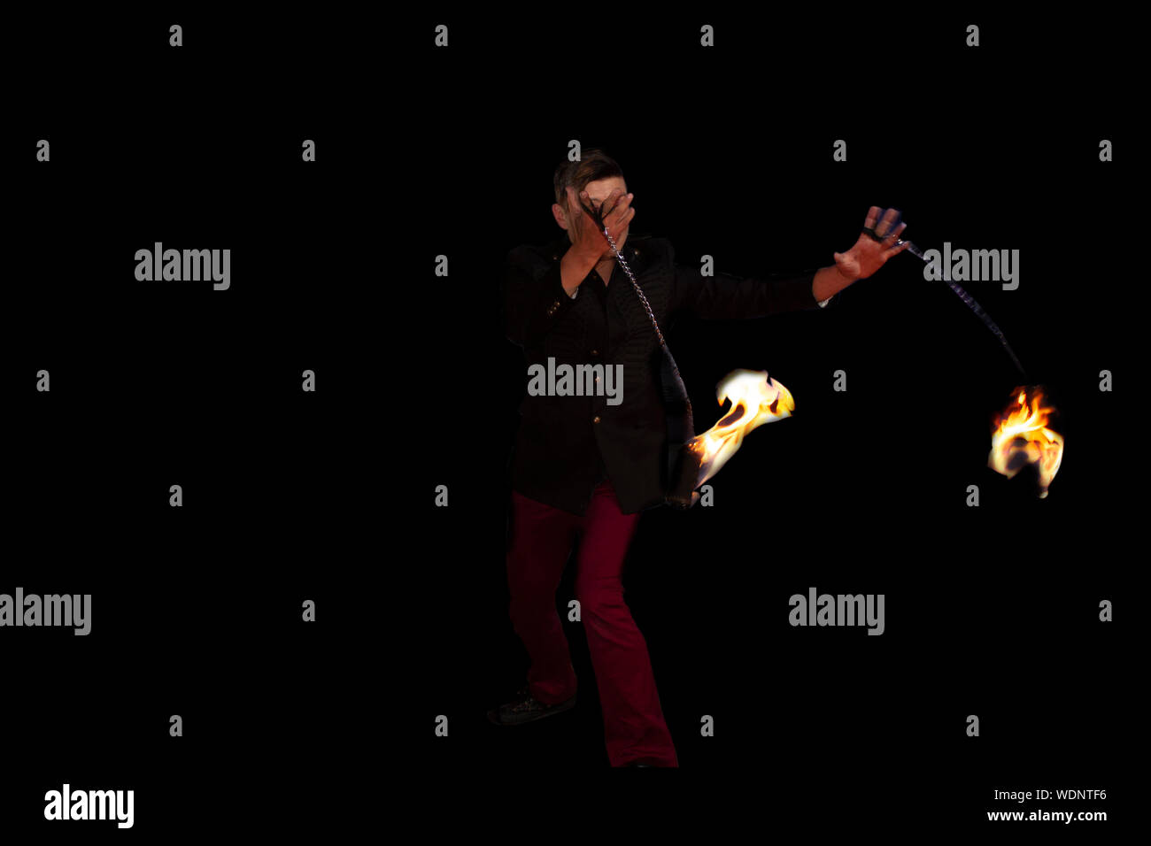 Man moving chains with fire points to give a show with acrobatics on ...