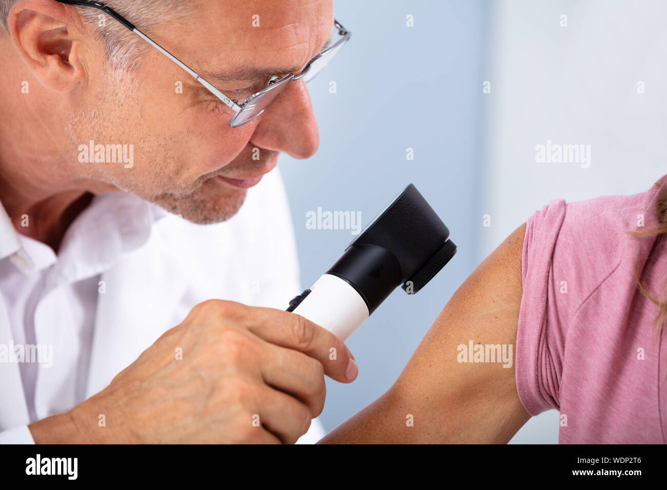 Close-up Of A Doctor Checking Skin Of Female Patient With Dermatoscope ...