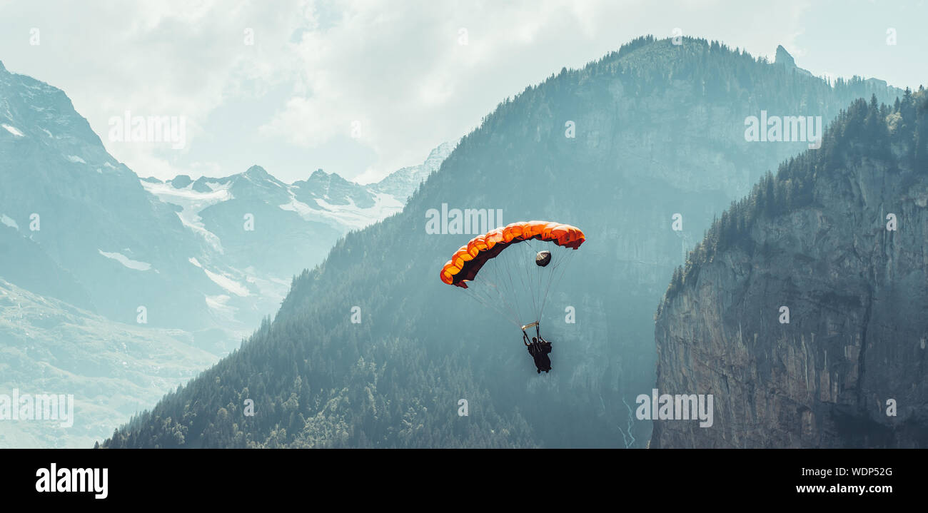 A BASE jumper prepares to touchdown in a field near Interlaken with the ...