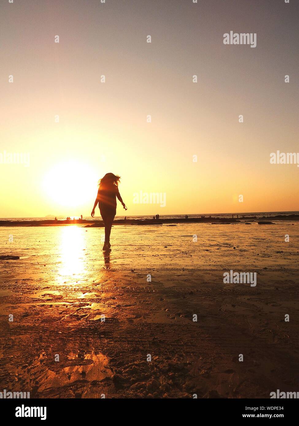 Woman walking along beach hi-res stock photography and images - Alamy