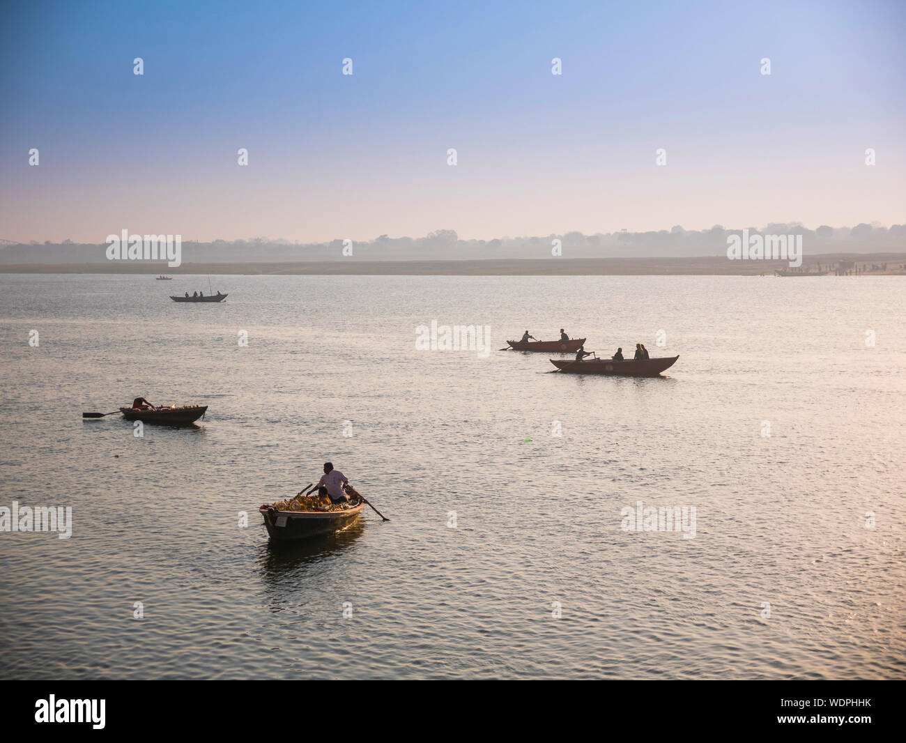 Wooden boats rowing down the Ganges River, Varanasi, Uttar Pradesh ...