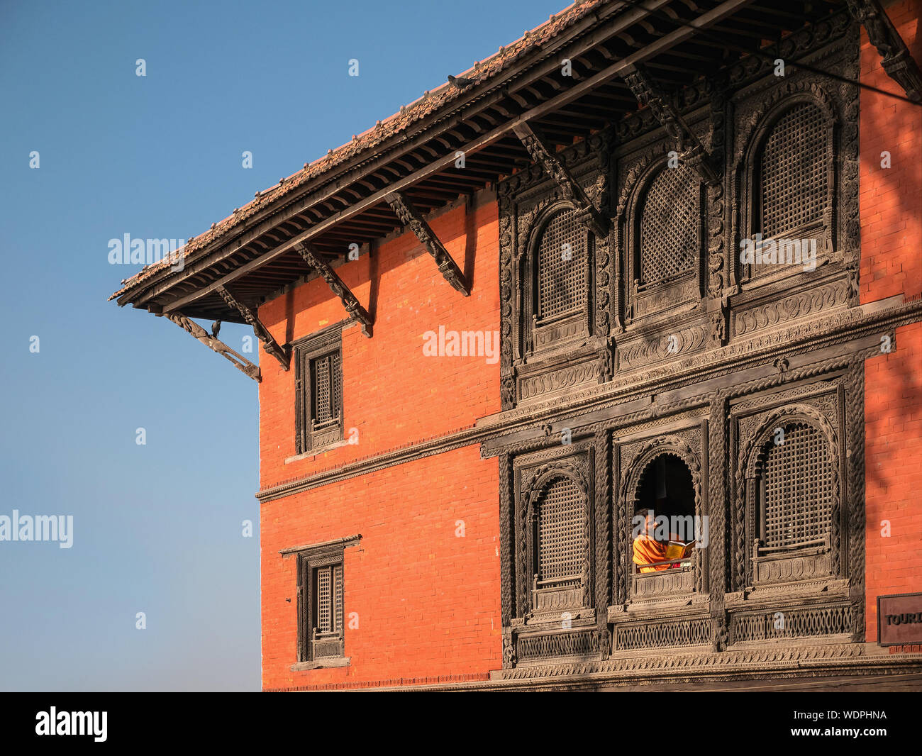 Sadhu holy man sitting in window, reading at Ancient Hindu Nepali ...
