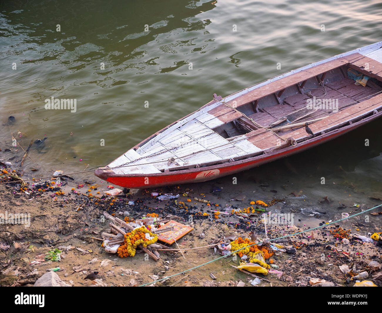 Wooden boat on shore of the Ganges River in Varanasi, Uttar Pradesh ...