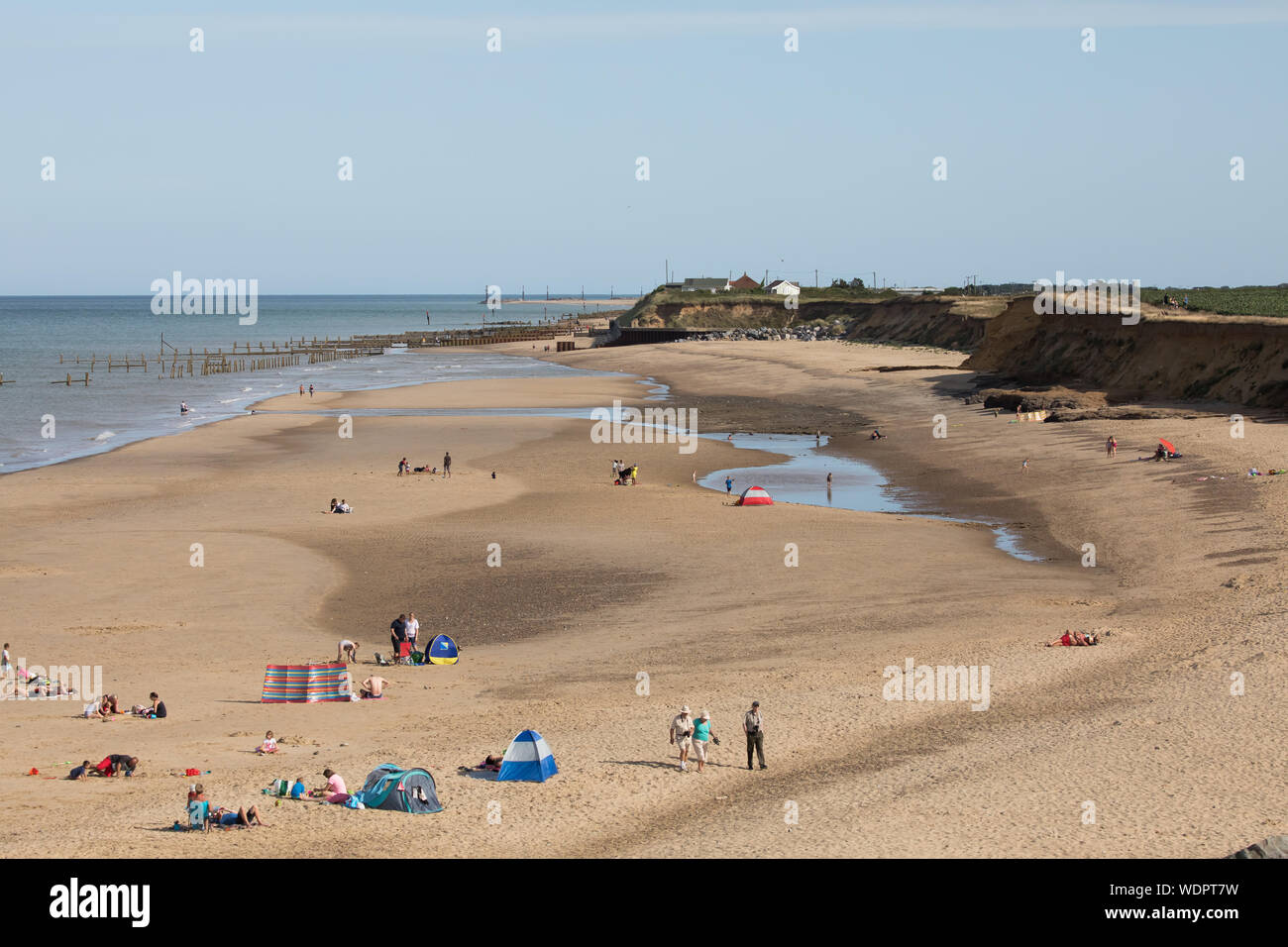 People enjoying the sunshine on Happisburgh Beach in Norfolk on a sunny ...
