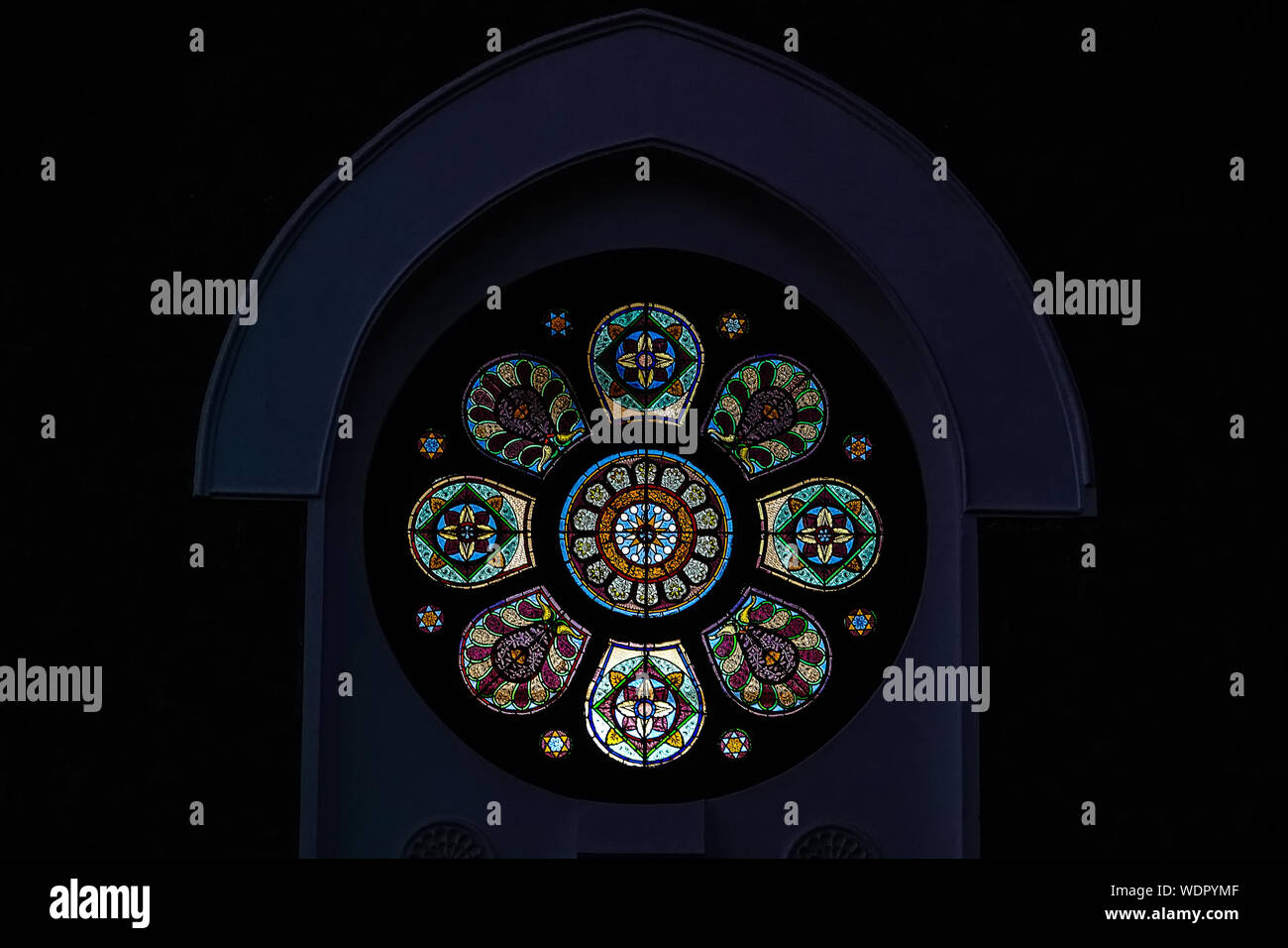 A dim old church interior lit by light rays penetrating through a ...