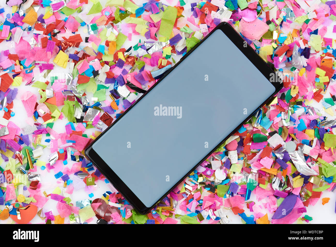 Modern smartphone on colorful confetti background Stock Photo - Alamy