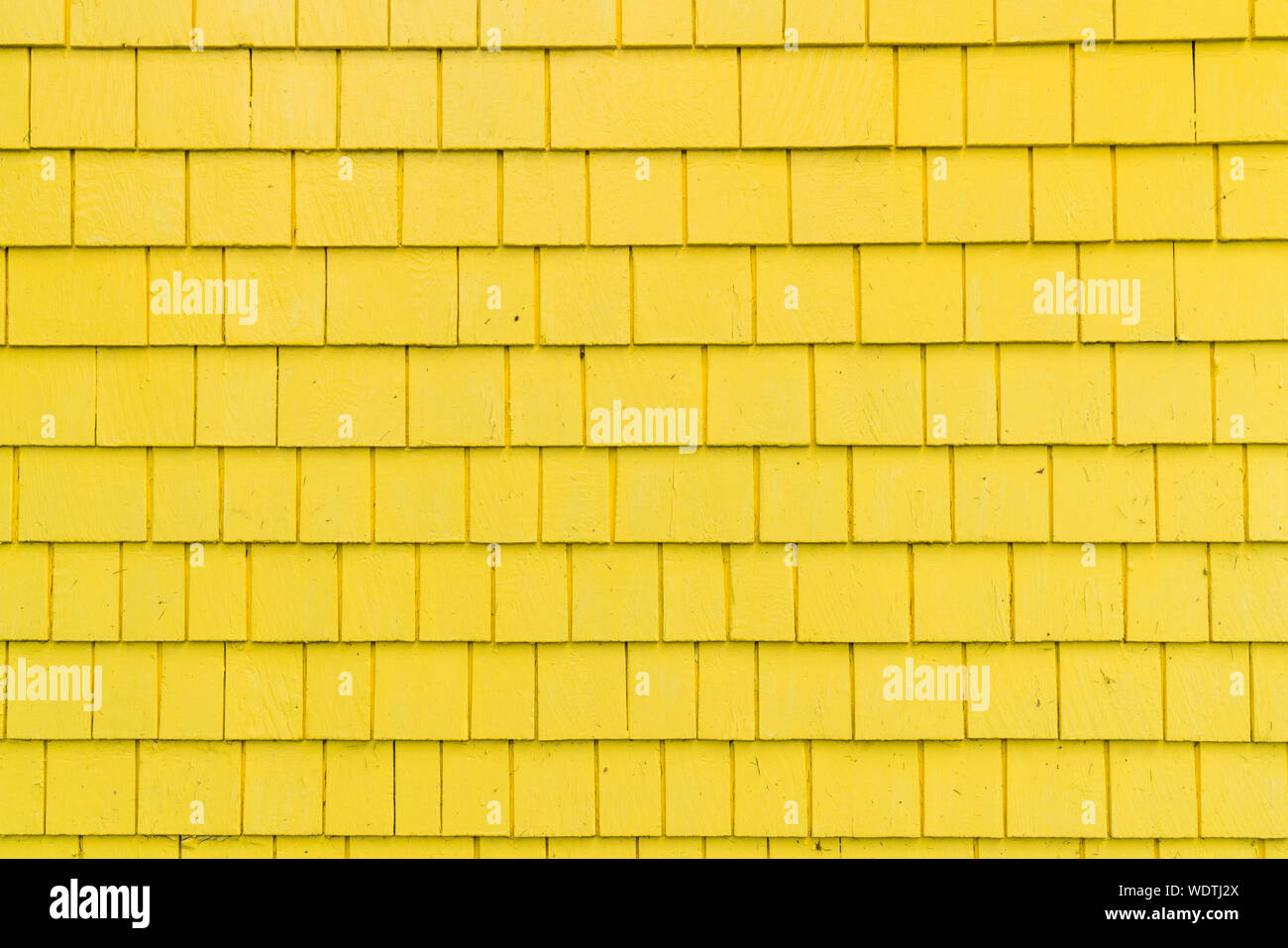 Exterior wall with bright yellow shingles Stock Photo - Alamy